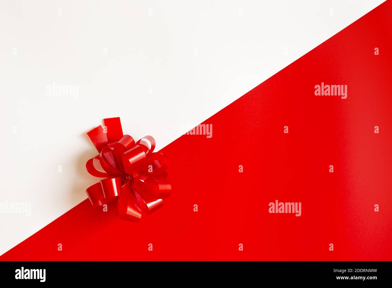Red plastic bow on a red and white diagonal paper texture Stock Photo ...
