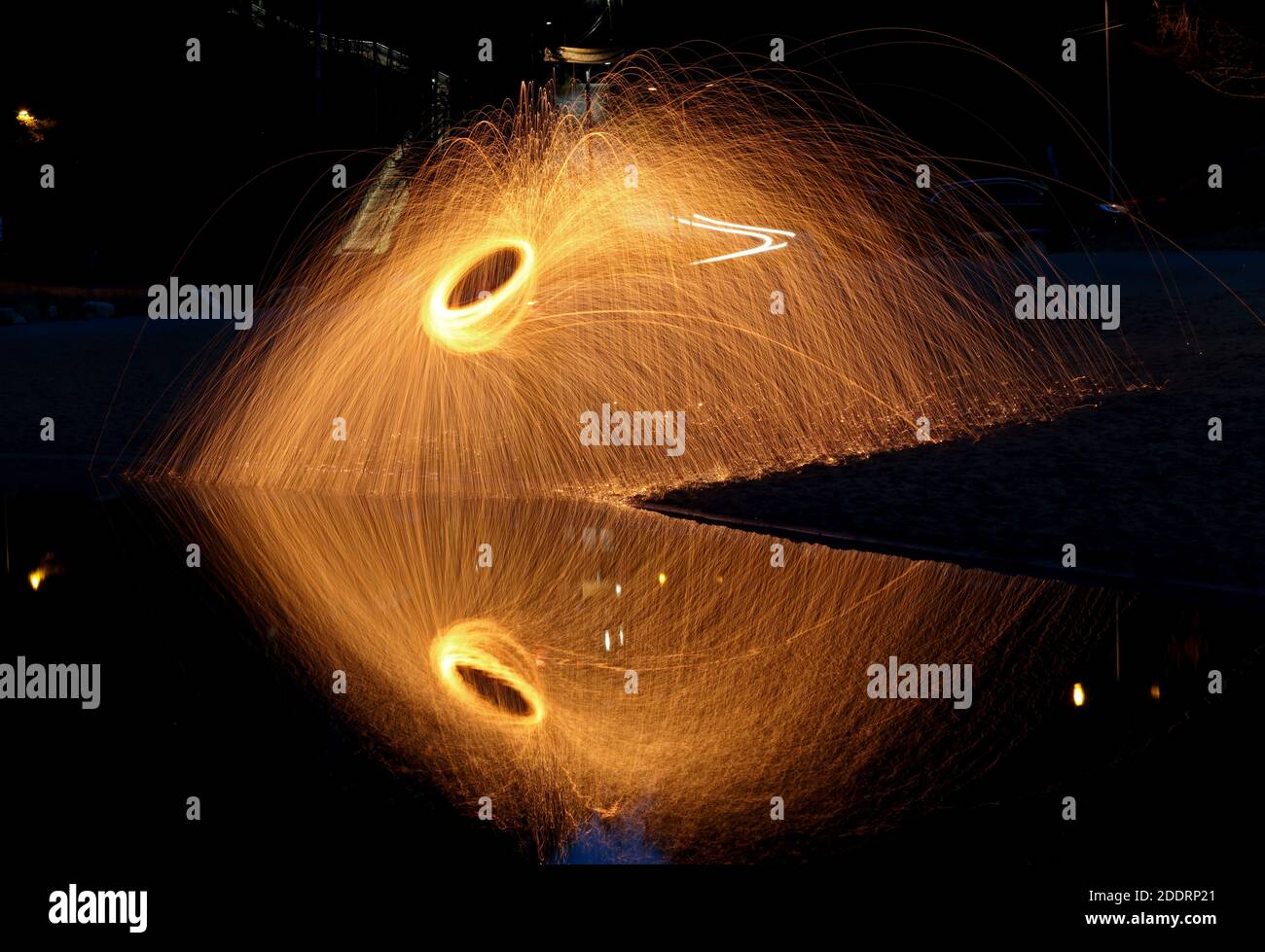 Steel wool burning and spinning on a lake shore Stock Photo - Alamy
