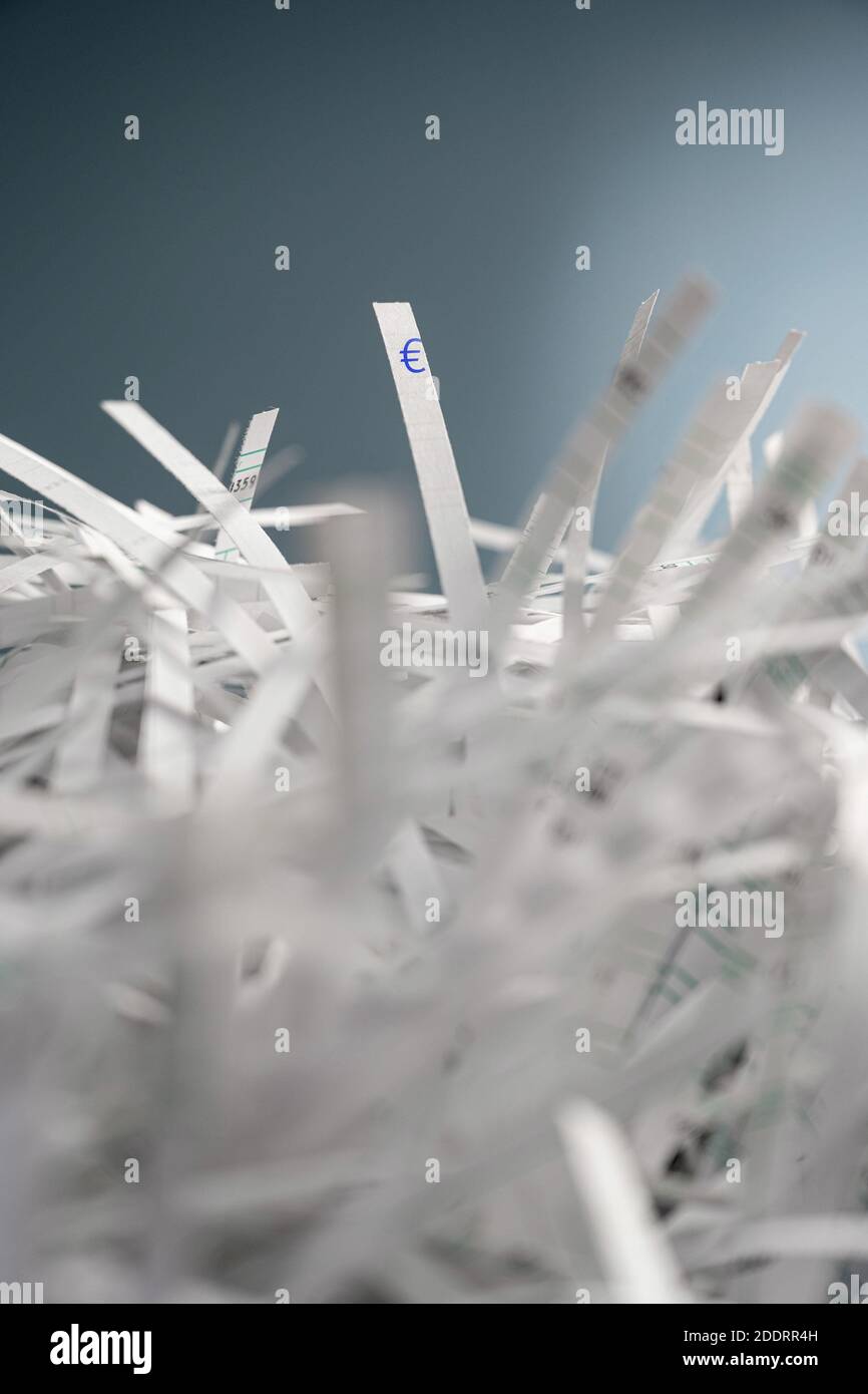 A pile of shredded paper strips and on one strip a Euro symbol is ...