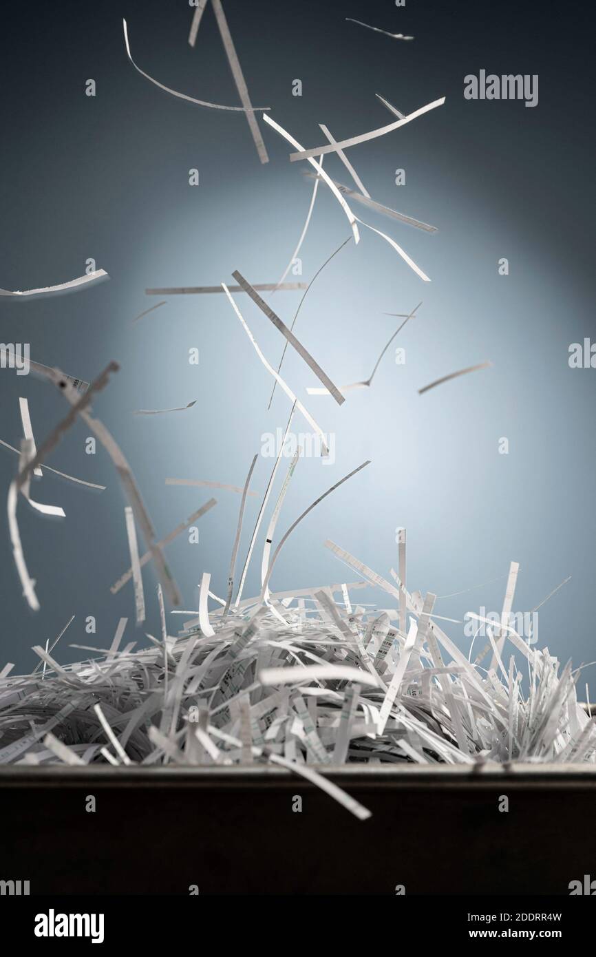 A pile of shredded paper strips lie in a metal box and from above, more ...