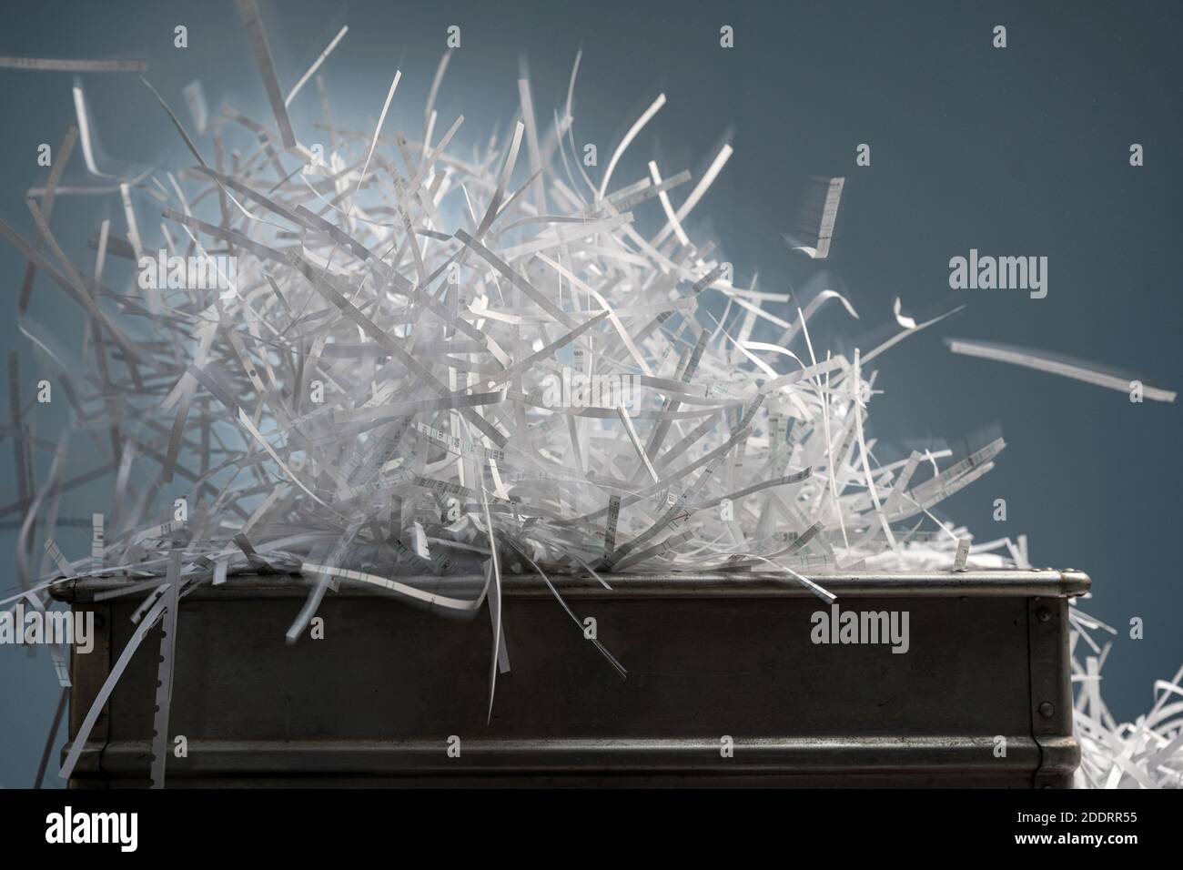 Shredded paper stripes seem to explode in a box and expand their volume ...