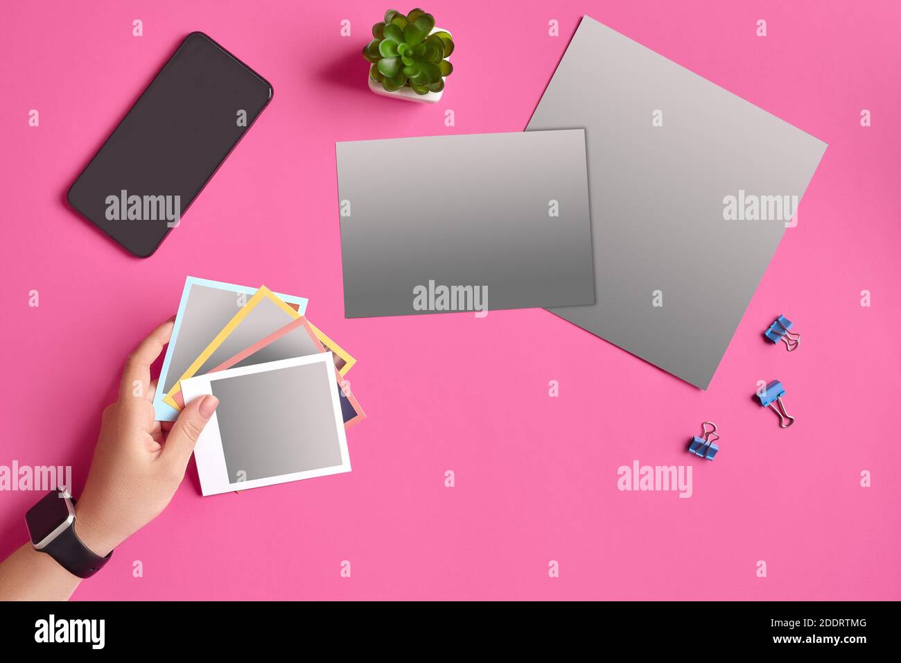 Hand of woman holding snapshot pictures, smartphone, sheets of ...