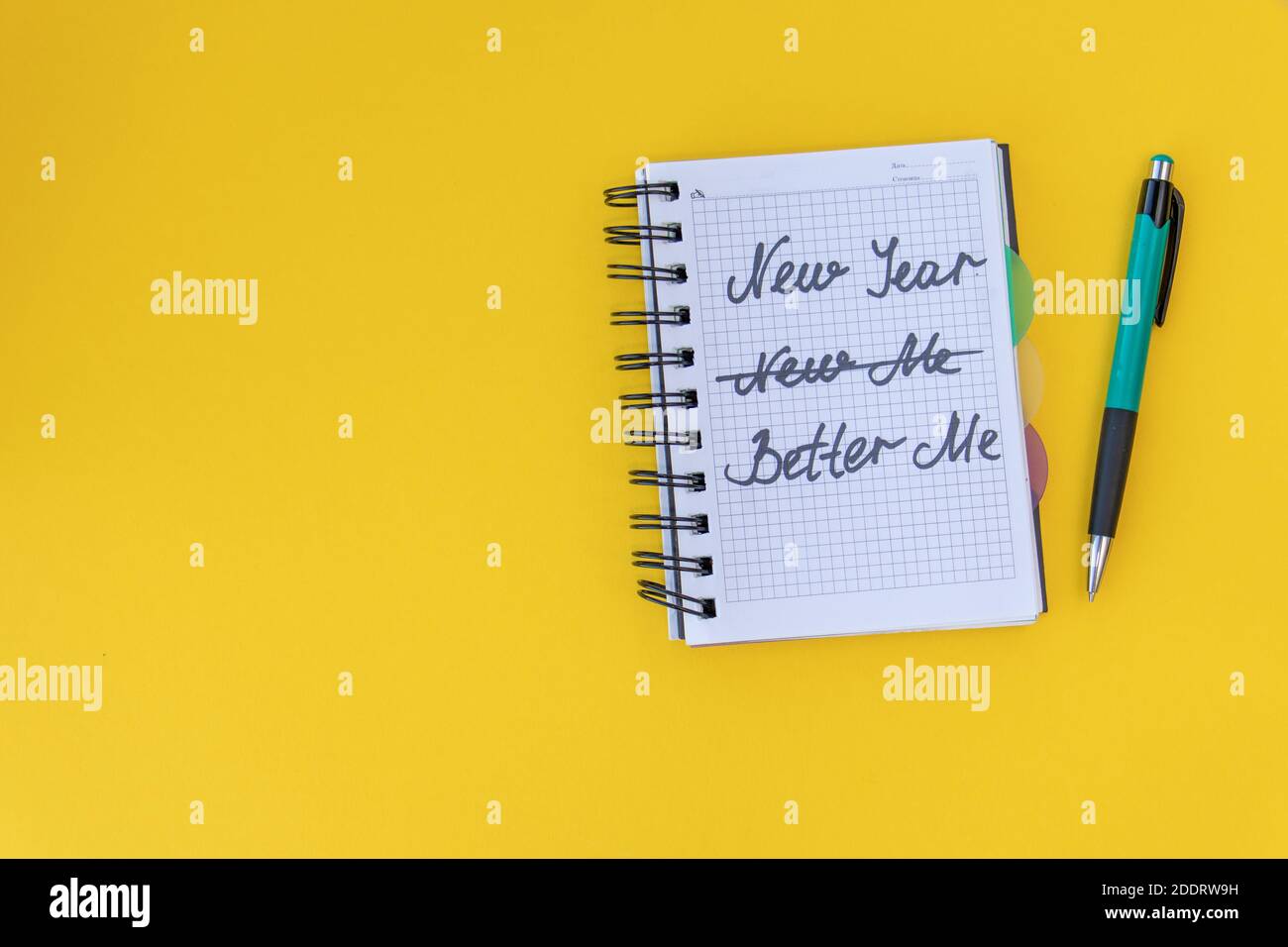 Writing in a notebook New year, better me on yellow background Happy ...