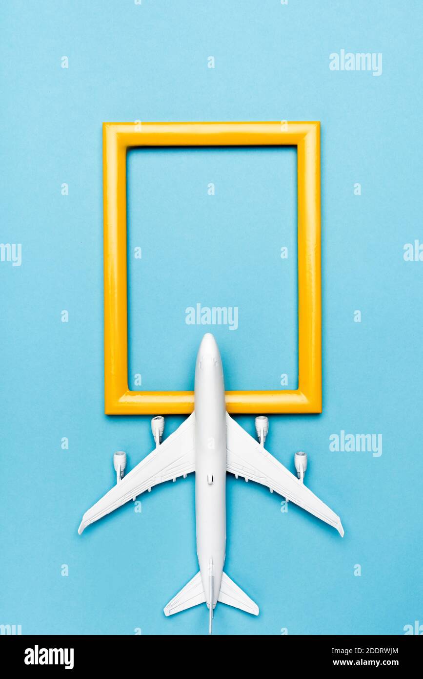 top view of white plane model and empty frame on blue background Stock ...