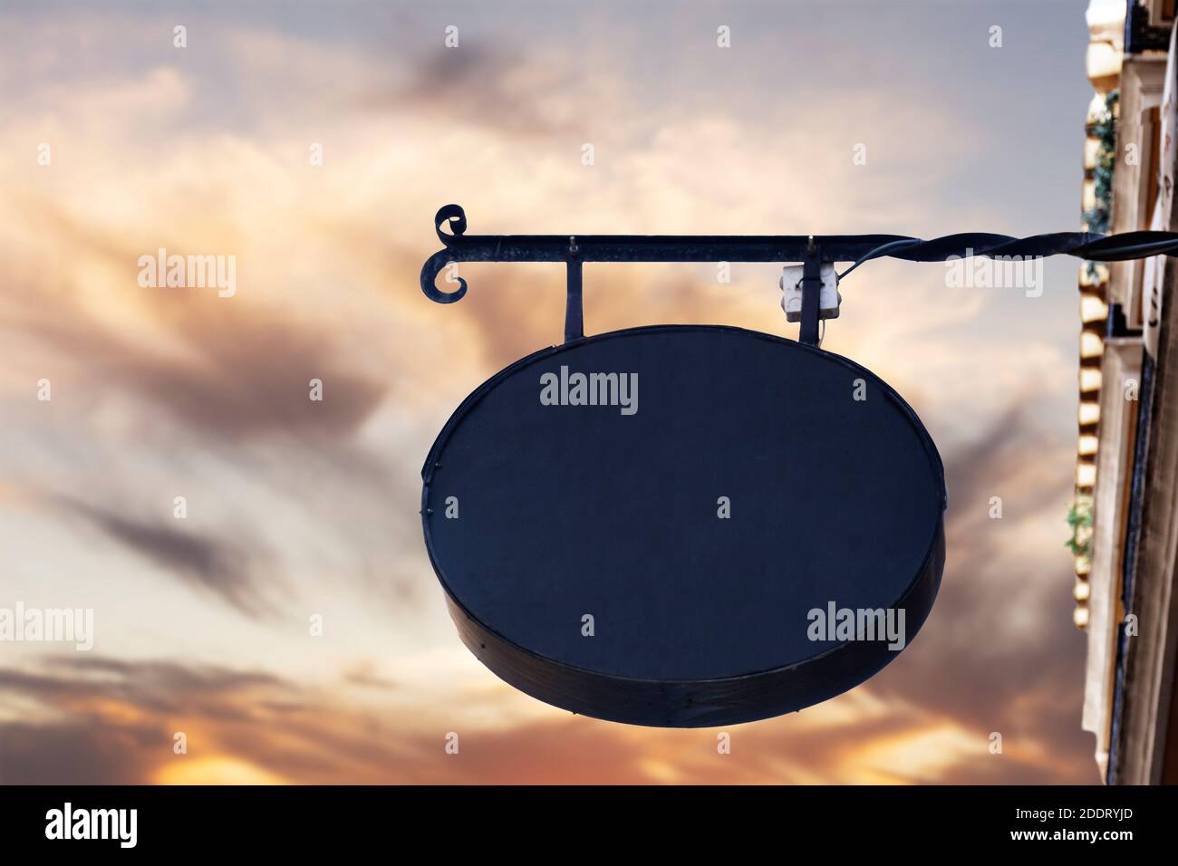 Black metal hanging sign on the facade of a building at the entrance of ...