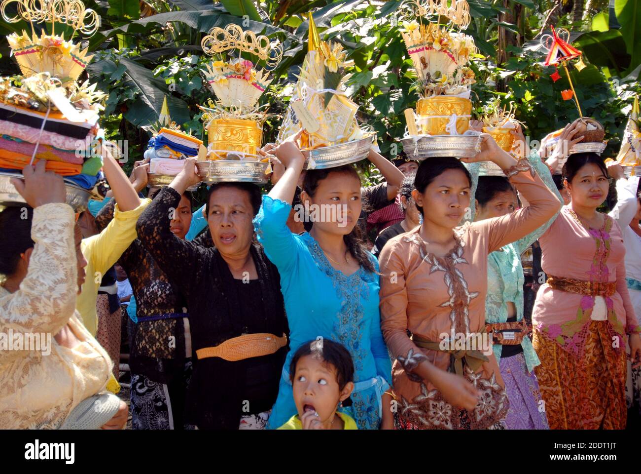 women wearing traditional dresses, carry offers for a funeral, in Bali ...