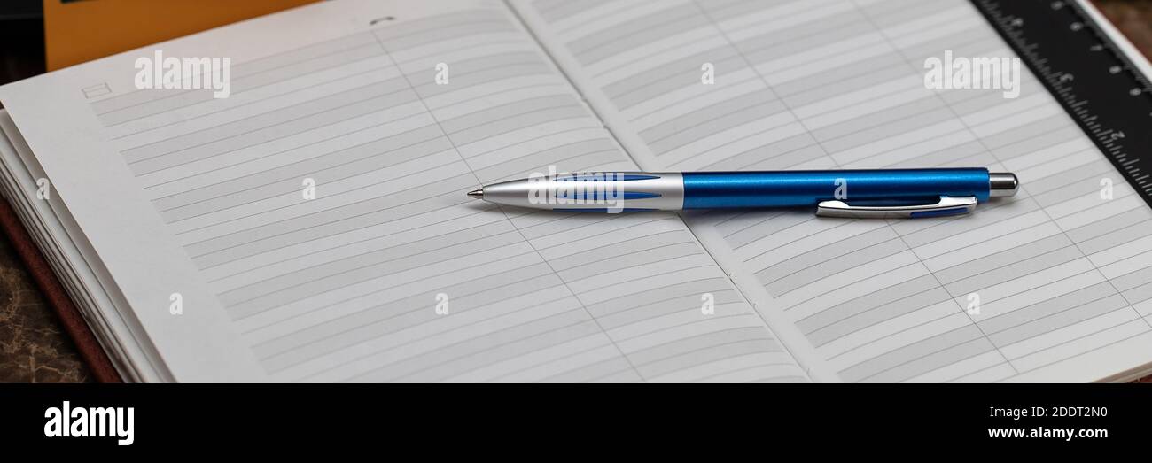 The pen lies on a white blank sheet of a diary. Close-up, selective ...