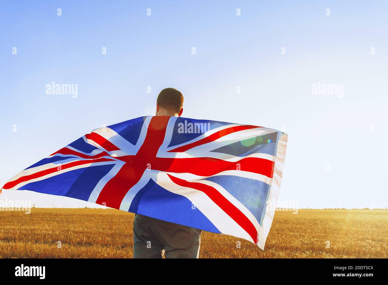 Man with a flag of Great Britain standing in field Stock Photo - Alamy