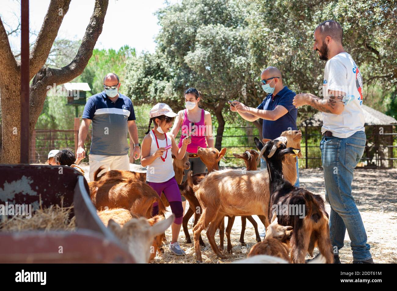 family group at the farm school with goats and a monitor giving a class ...