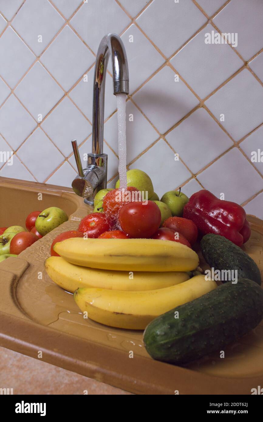 The kitchen faucet cleans fruits and vegetables. A stream of tap water ...