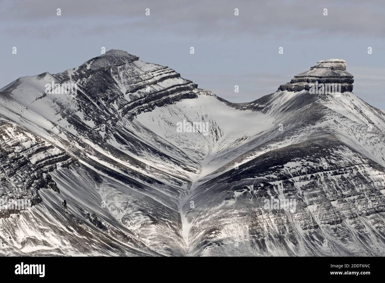 Snow covered Carboniferous mountain slope showing strata in autumn ...