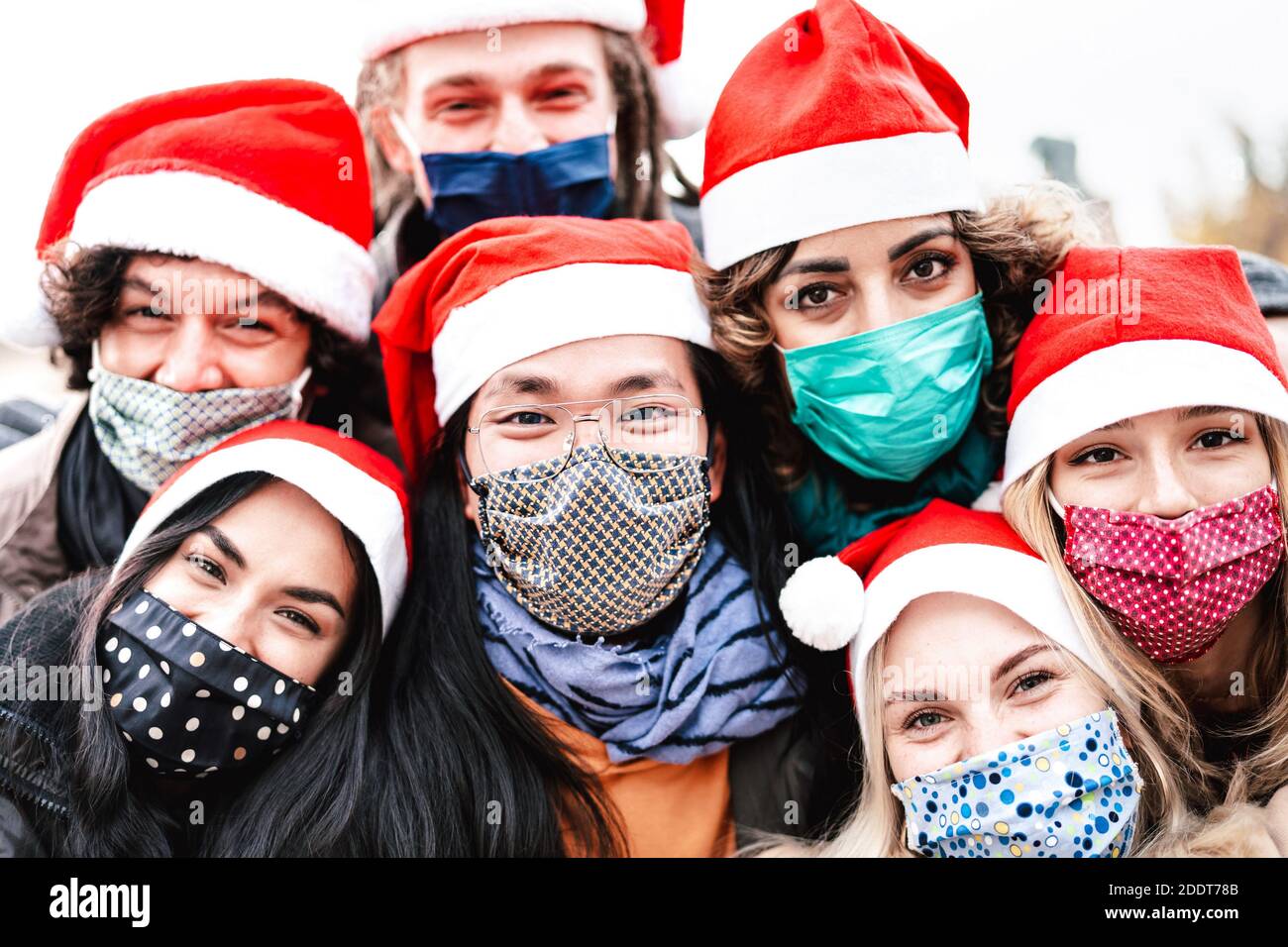 Close up photo of friends taking selfie wearing face mask and santa hat ...