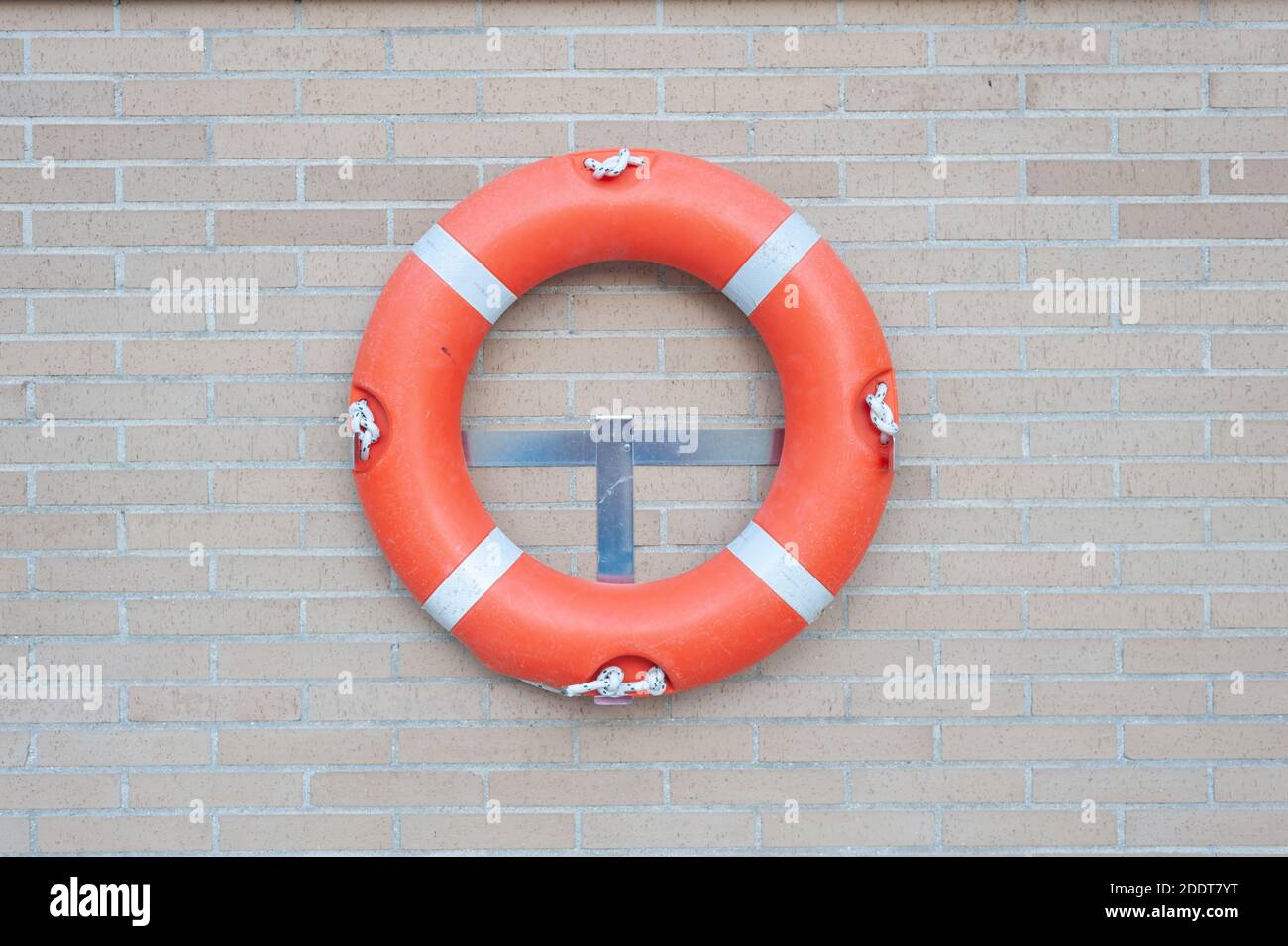 red life preserver hooked on a brick wall Stock Photo - Alamy