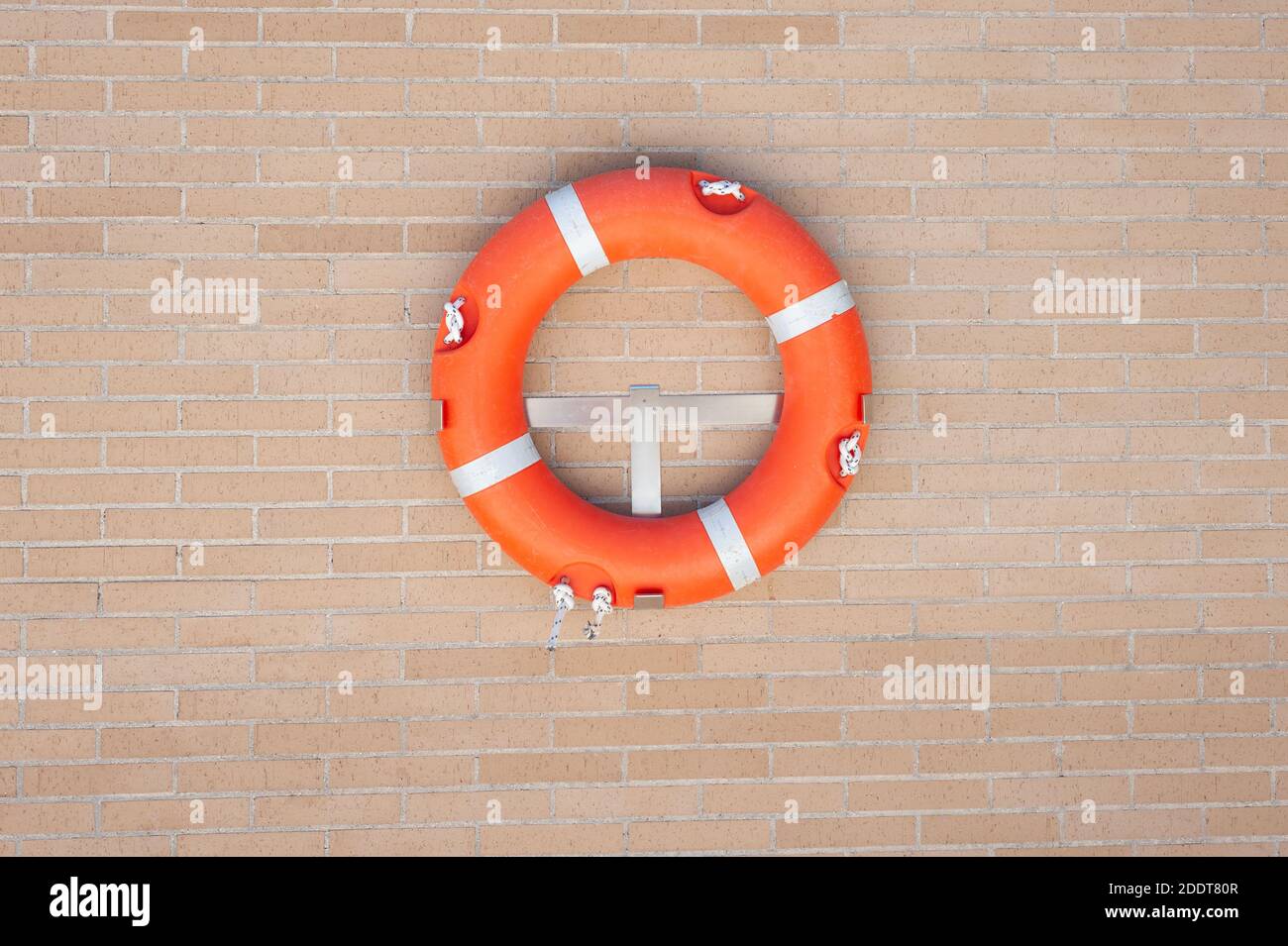 red life preserver hooked on a brick wall Stock Photo - Alamy
