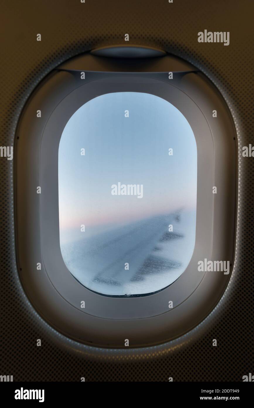Airplane window overlooking the right wing seen from inside the ...