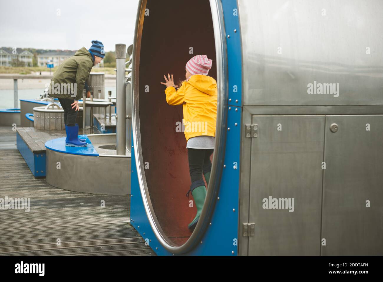Teen girl running in a wheel on playground in Scandinavia near sea ...