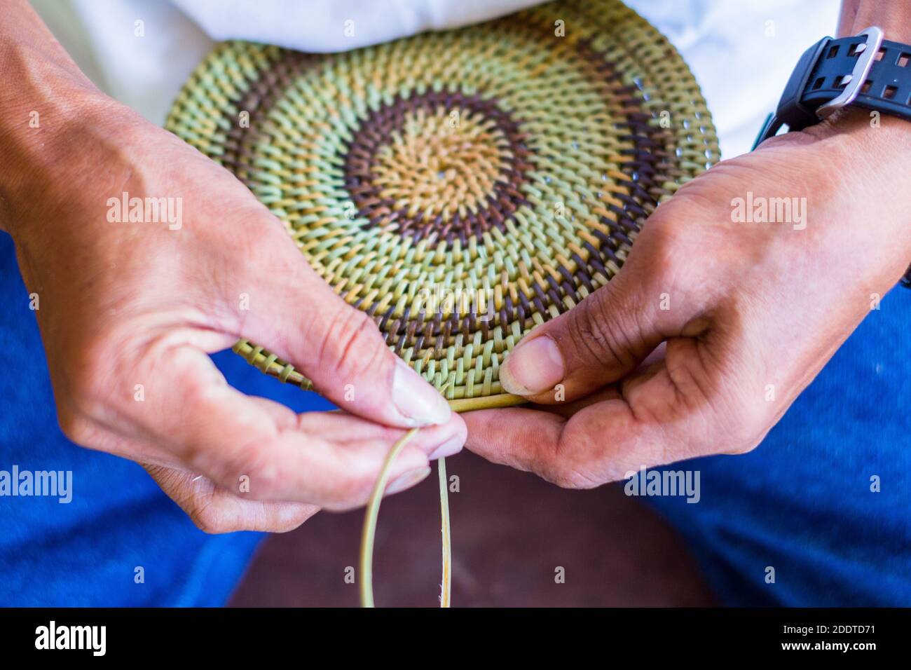 A pinikas artisan working on a basket using local materials at the ...