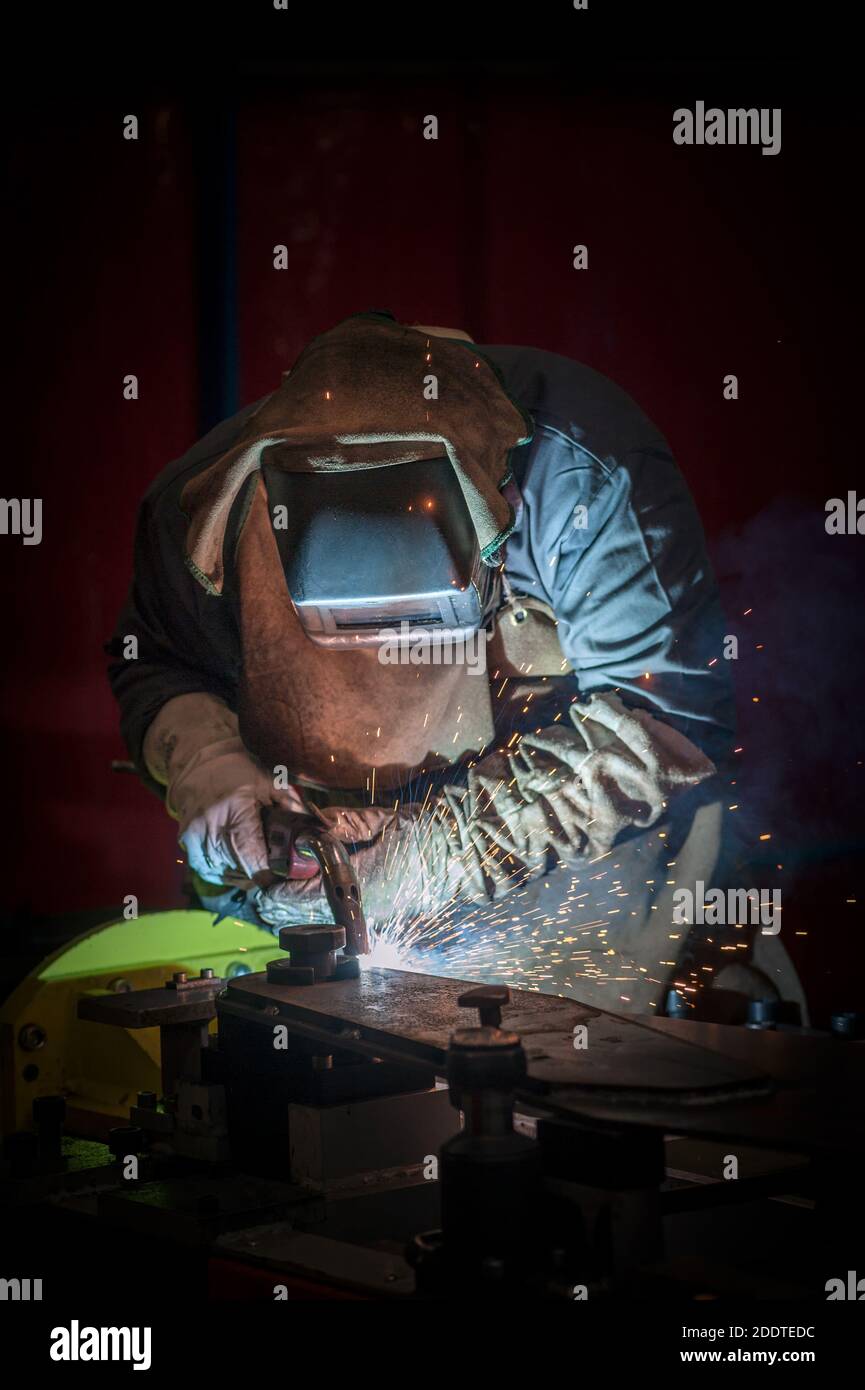 Welder at work in a factory in full protective gear - Personal ...