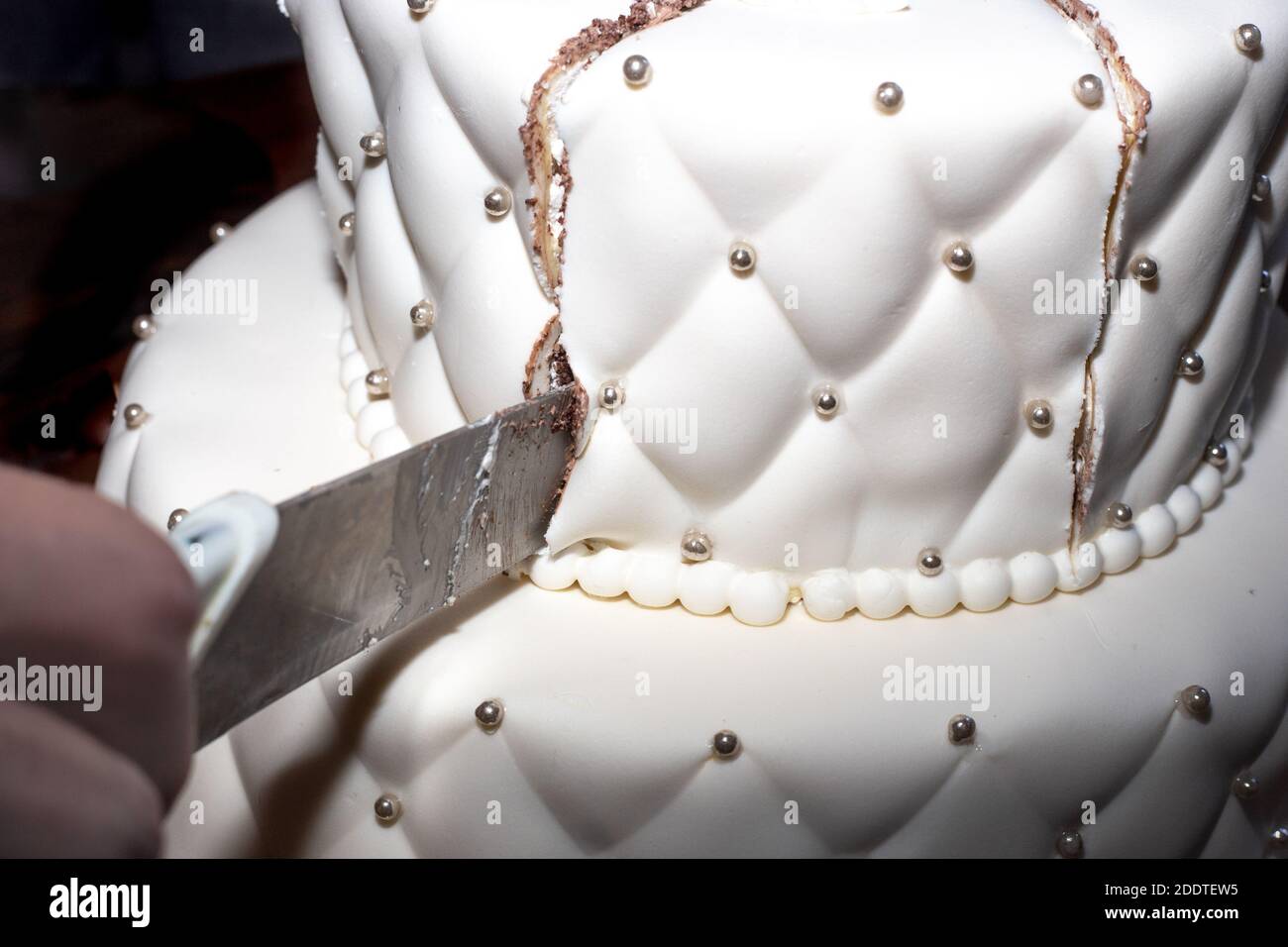cutting with a knife a festive white cake. Wedding design with ...