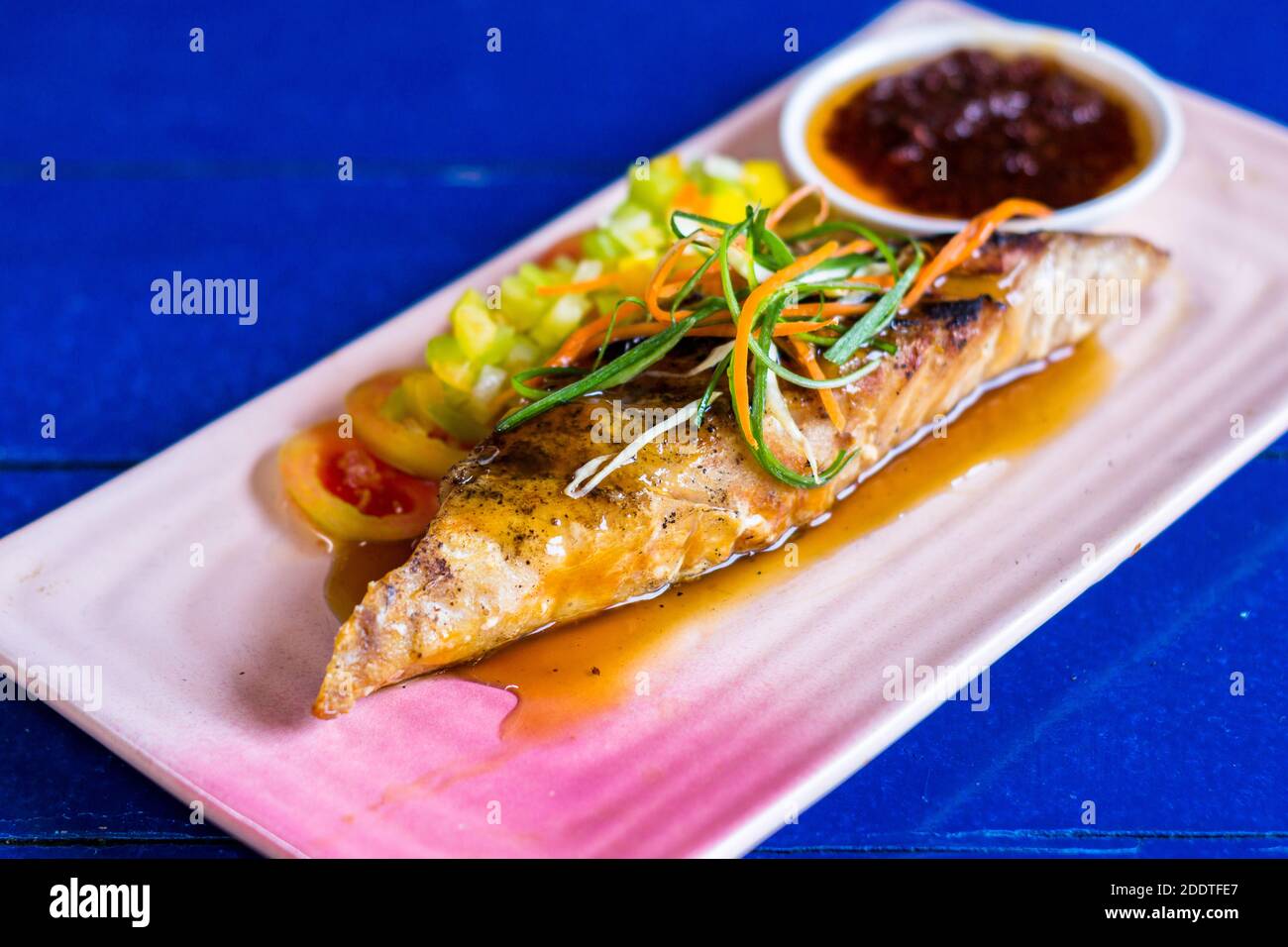 A dish of fried tuna steak with a side of chili sauce at a local ...