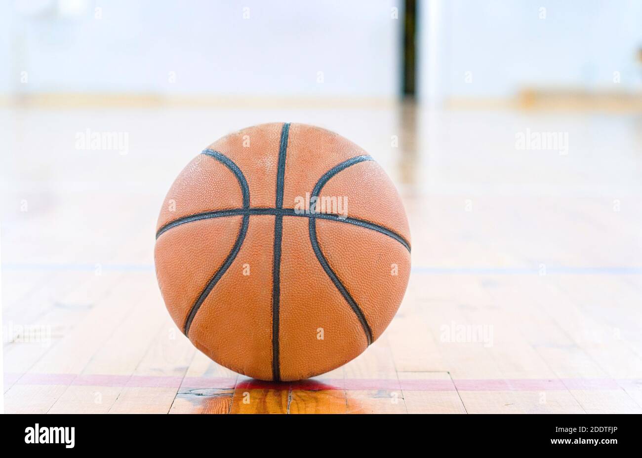 Basketball on Court Floor close up with blurred arena in background ...