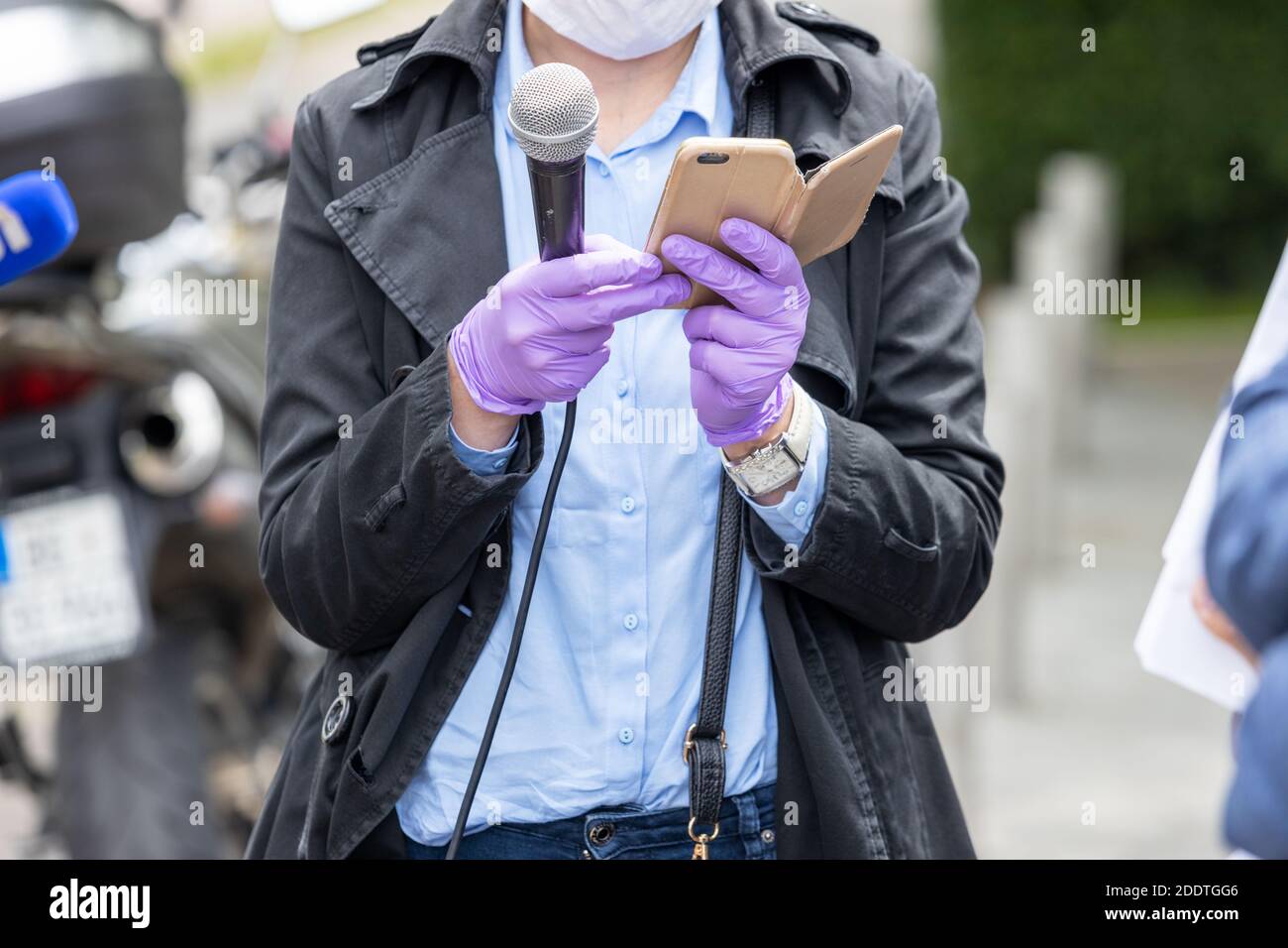 Female reporter wearing protective gloves and face mask against ...