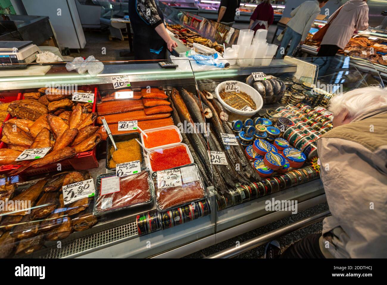Woman looking caviar tins in a smoked Fish stand in Riga Central Market ...