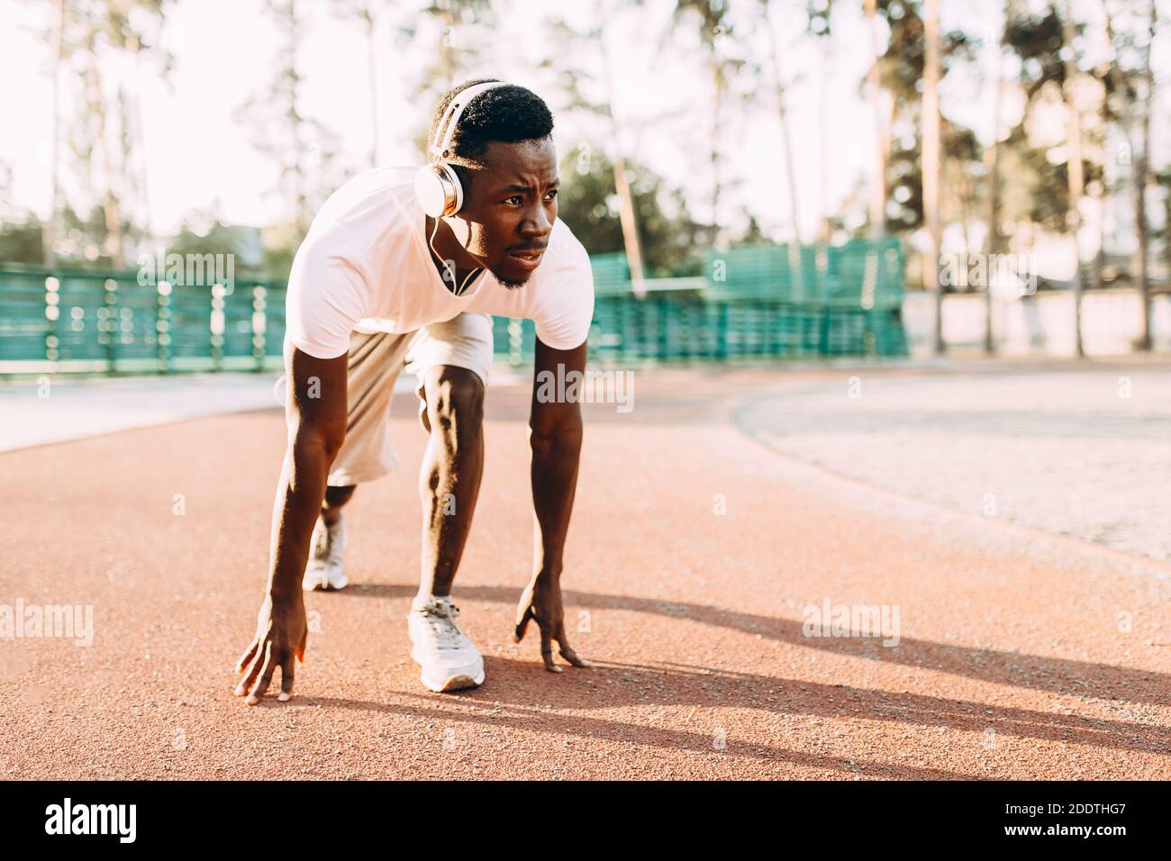Portrait of a young African-American athlete standing at the start of ...