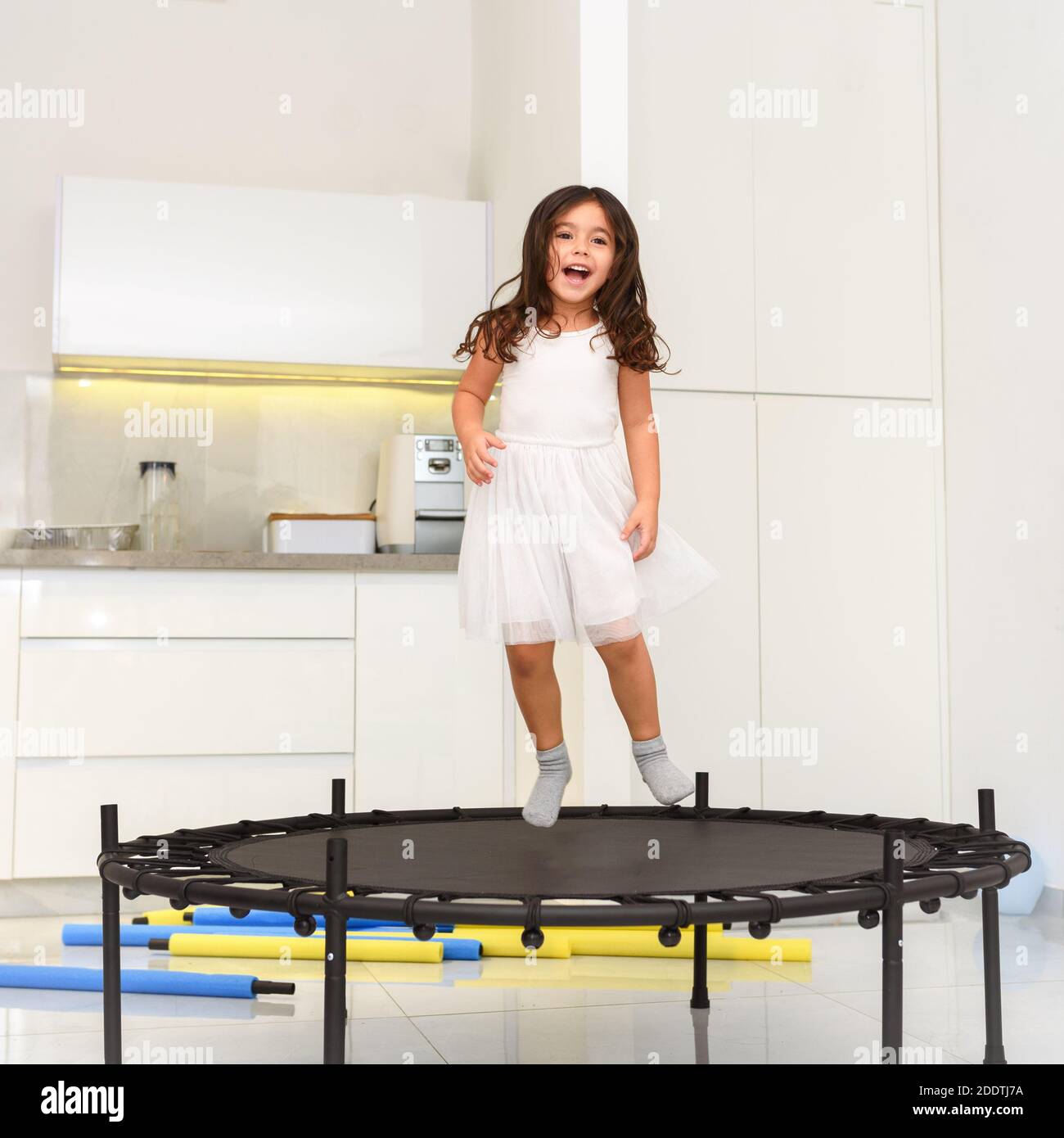 Happy little child jumping on trampoline in home Stock Photo - Alamy