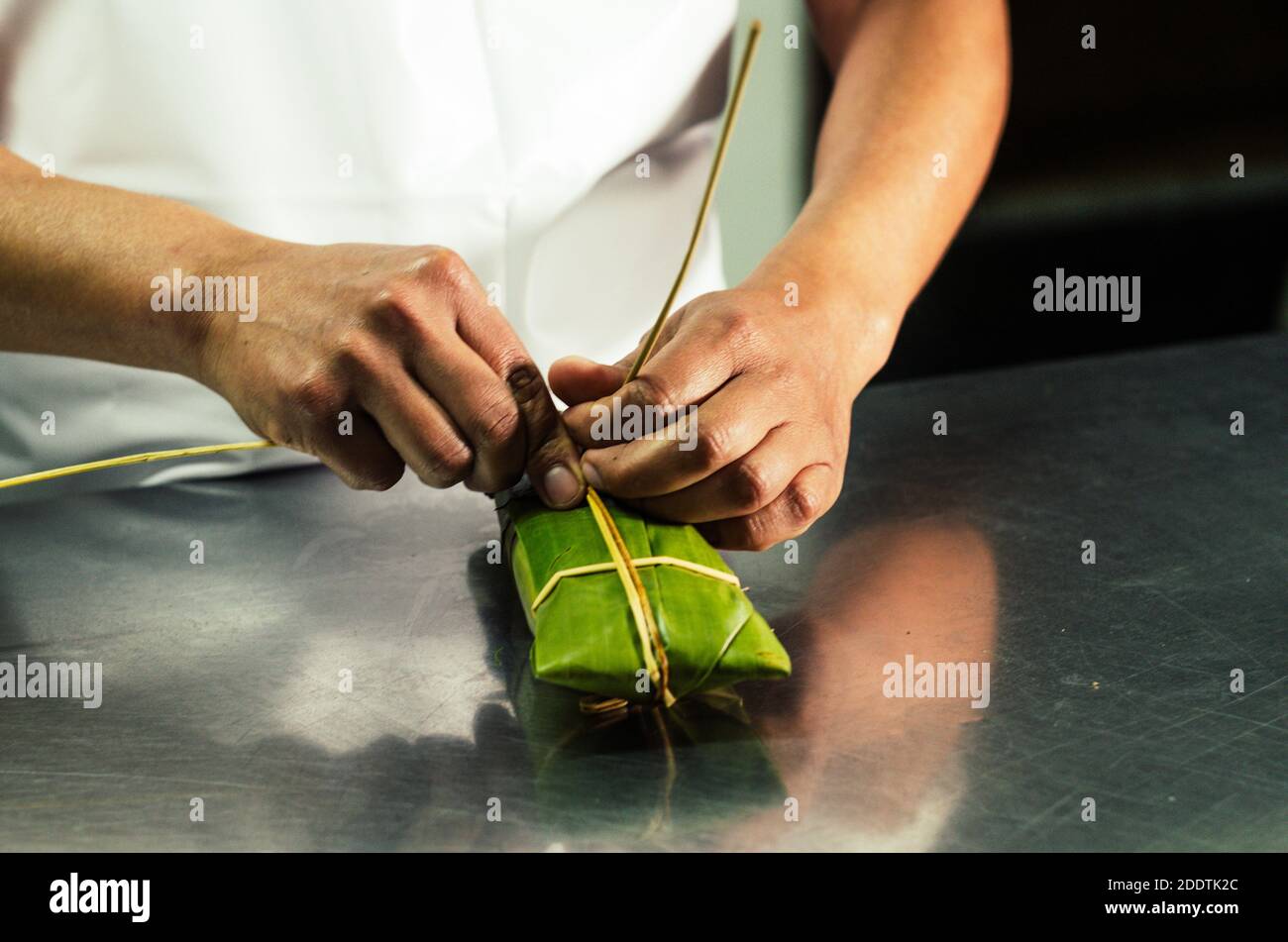Peruvian hands tying a traditional tamale with banana leaves Stock ...