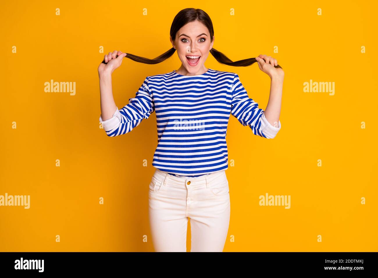 Portrait of crazy astonished girl hold her ponytails impressed anti ...