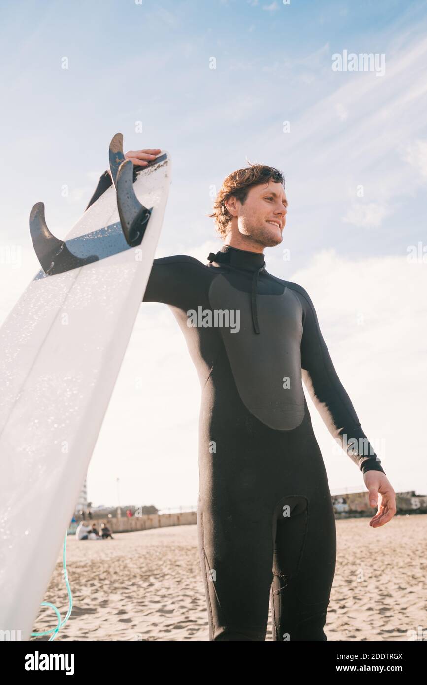 Surfer standing in the ocean with his surfboard Stock Photo - Alamy