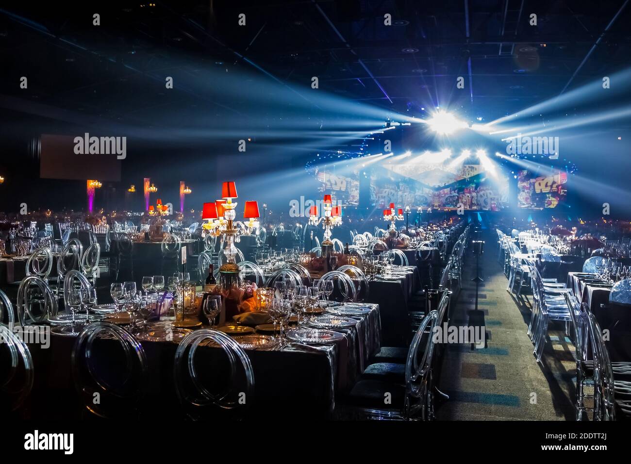 An illuminated dinner tables set up near a stage Stock Photo - Alamy