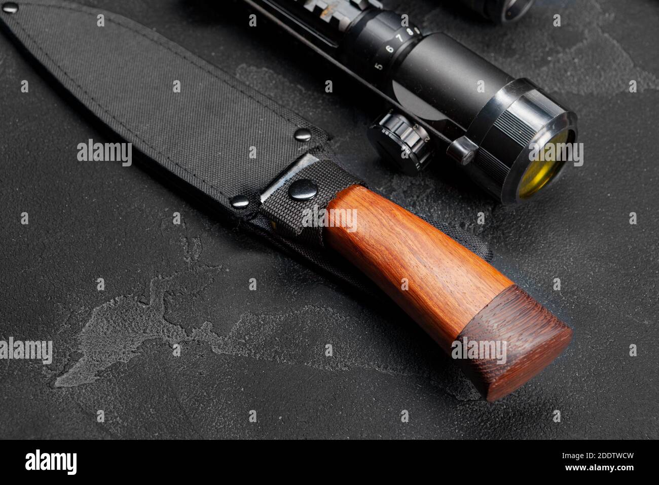 Hunting knife and optical sight for rifle on grey background Stock ...