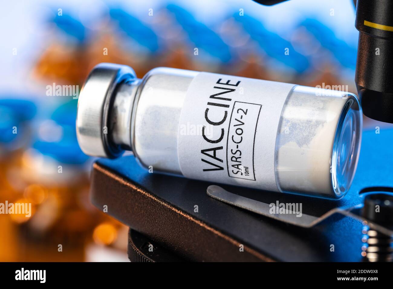 Vial of Covid-19 vaccine next to a microscope Stock Photo - Alamy