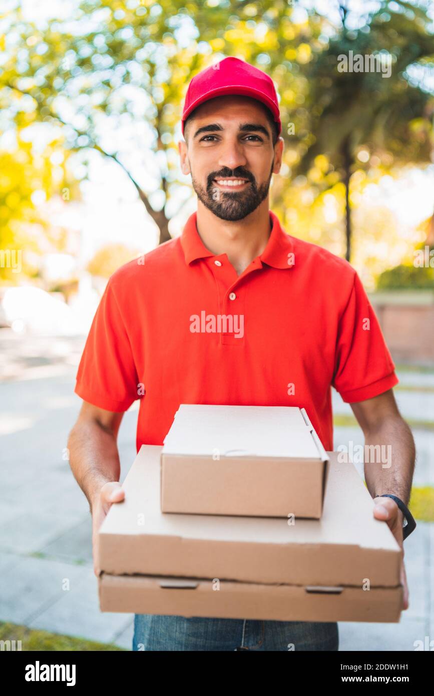 Delivery man with pizza box outdoors Stock Photo - Alamy