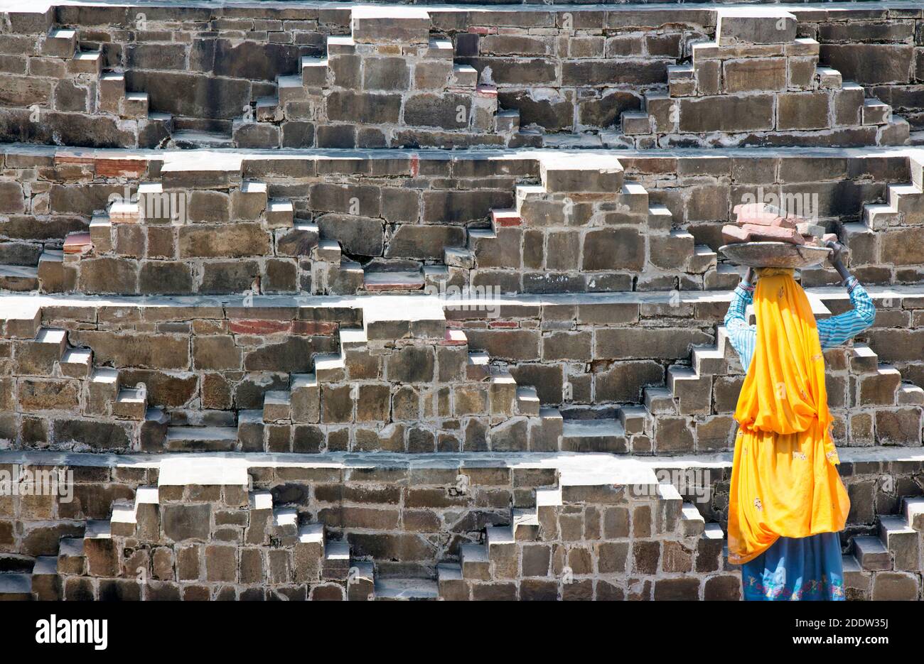 Indian woman carrying bricks in Chand Baori, the deepest stepped pit in ...