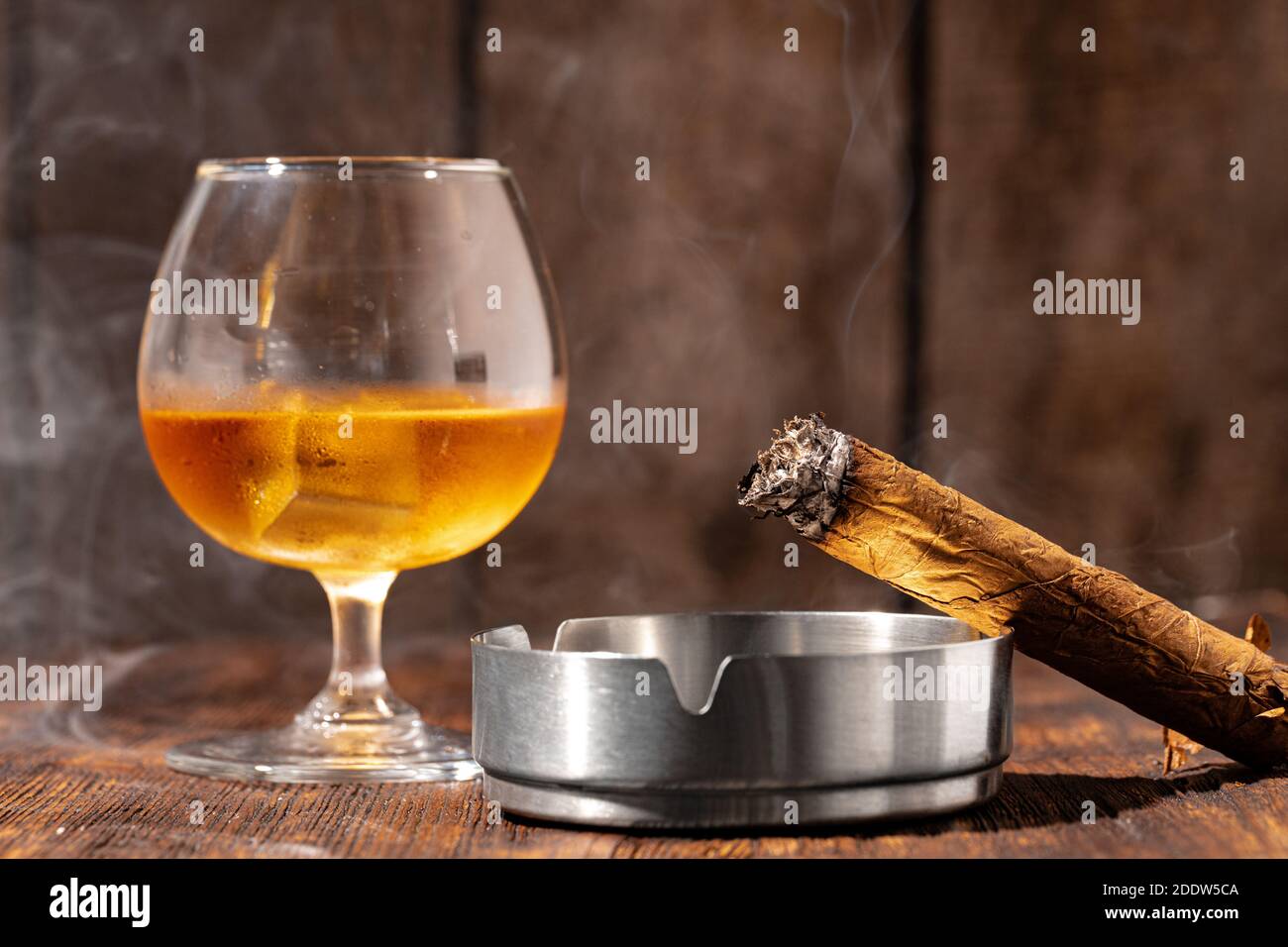Glass of whisky and lighted cigar in an ash tray Stock Photo - Alamy