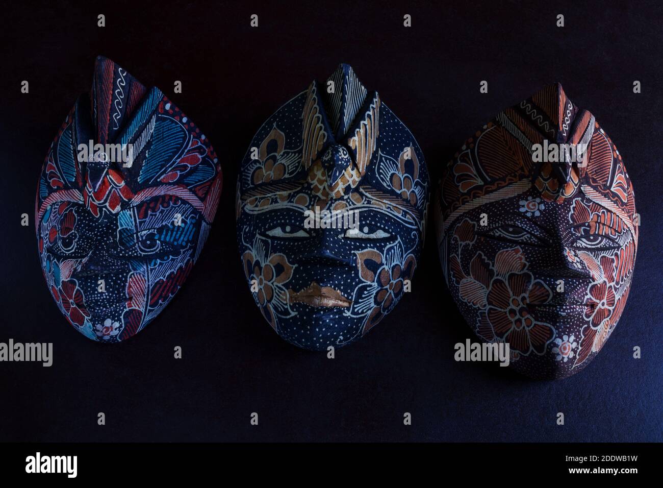 Colored handmade African masks carved from the wood of African on red ...