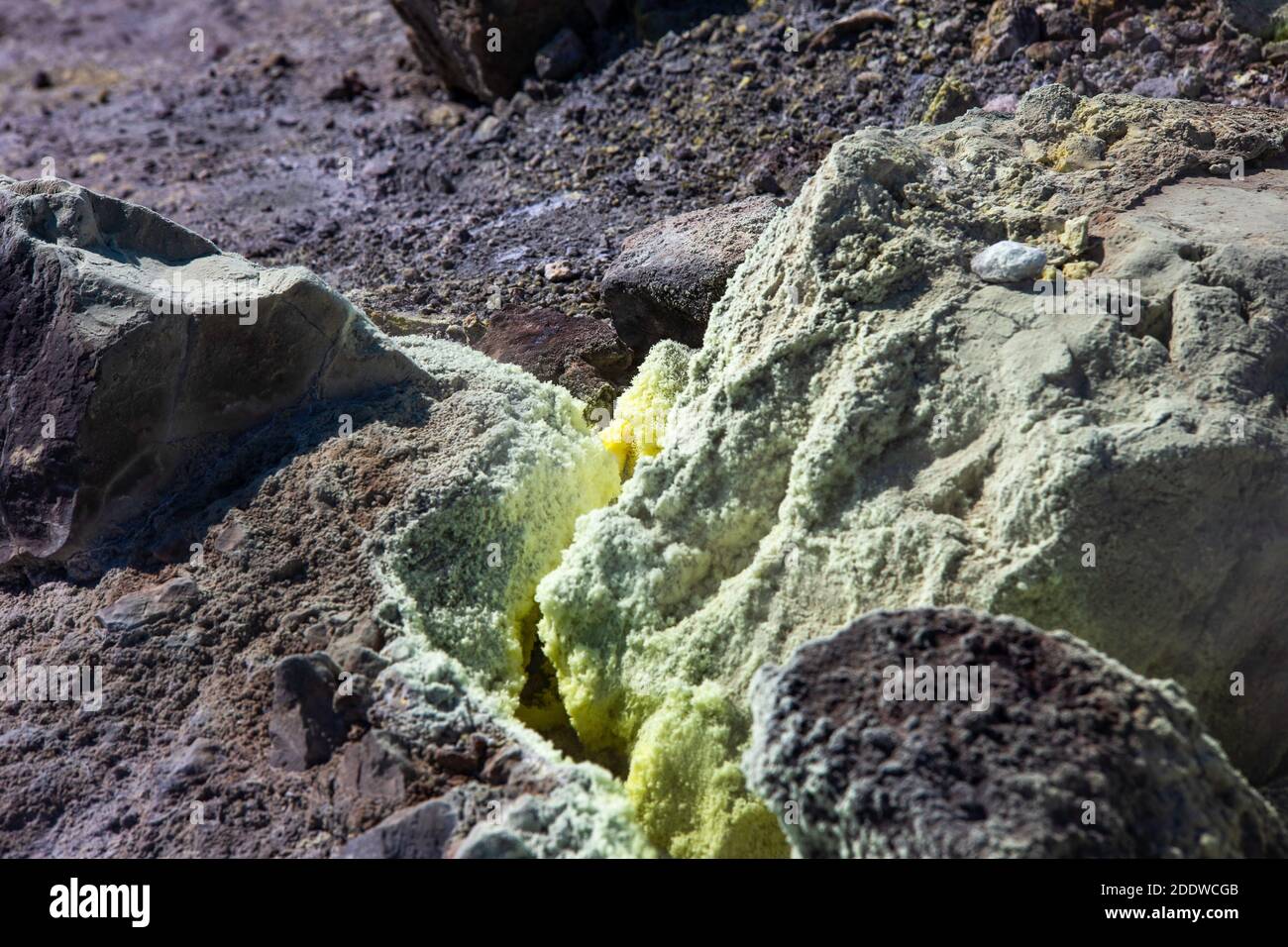 Sulfur haze and its crystals on the lava rocks. Volcano Island in the ...