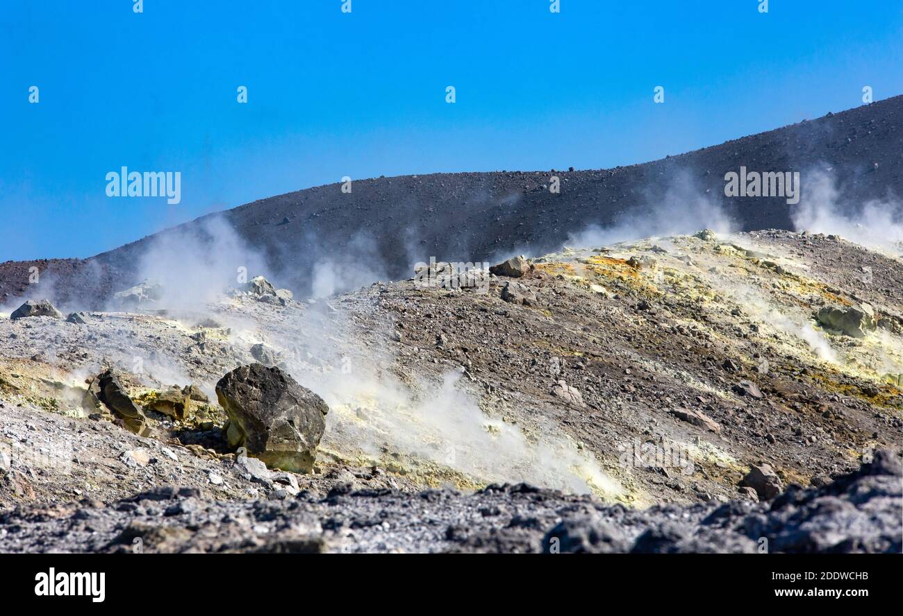 Sulfur haze and its crystals on the lava rocks. Volcano Island in the ...