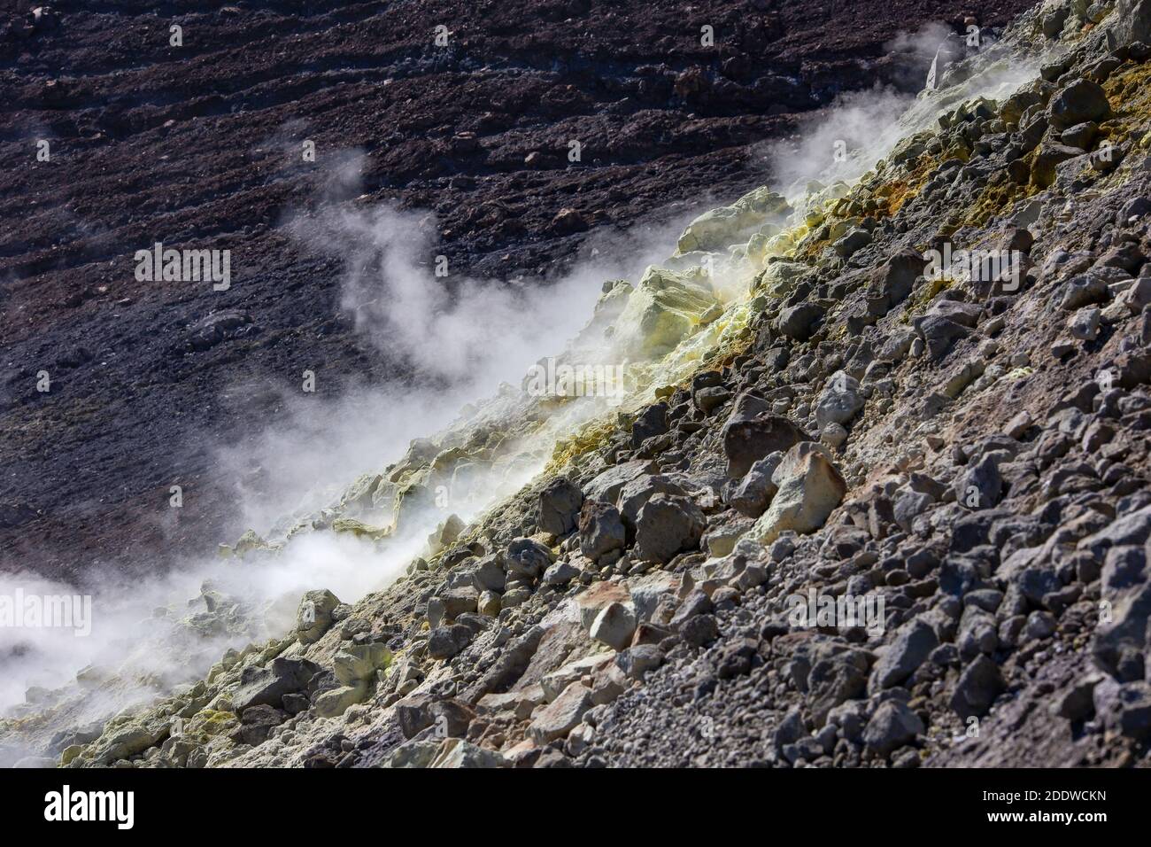 Sulfur haze and its crystals on the lava rocks. Volcano Island in the ...