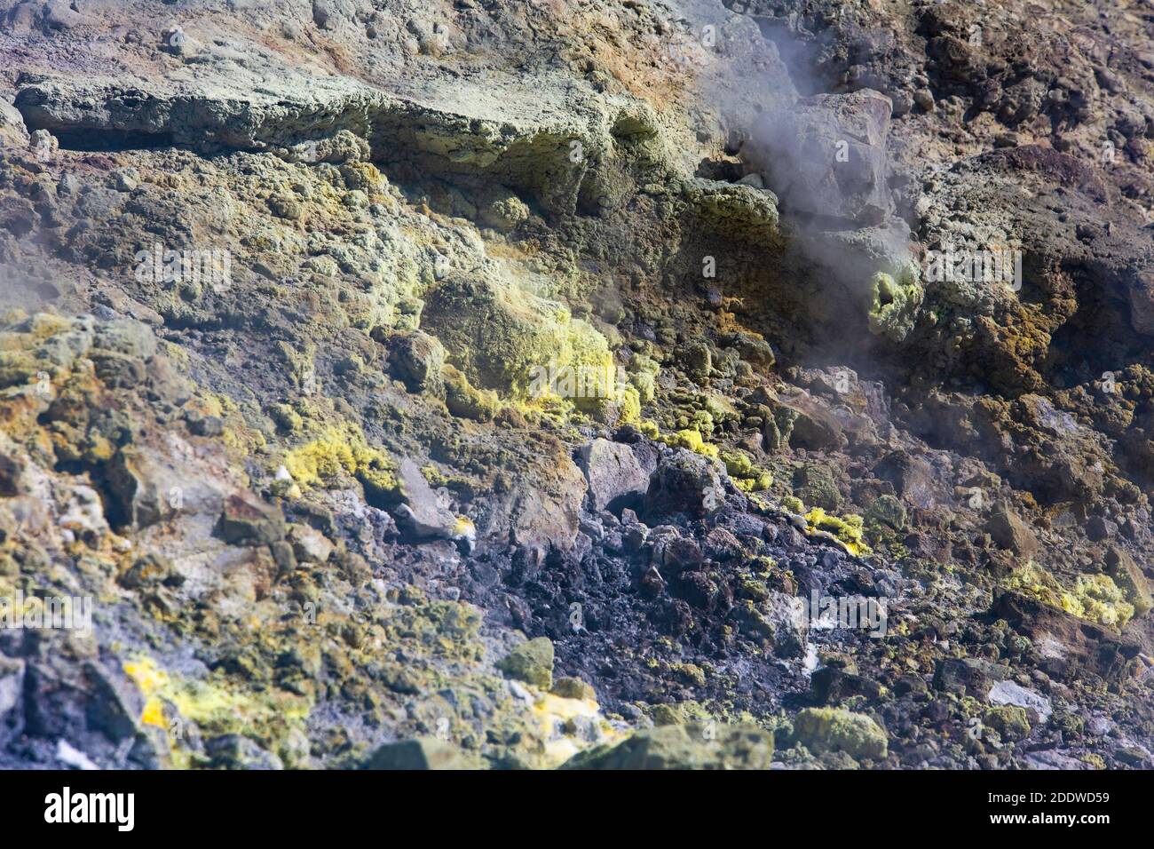 Sulfur haze and its crystals on the lava rocks. Volcano Island in the ...