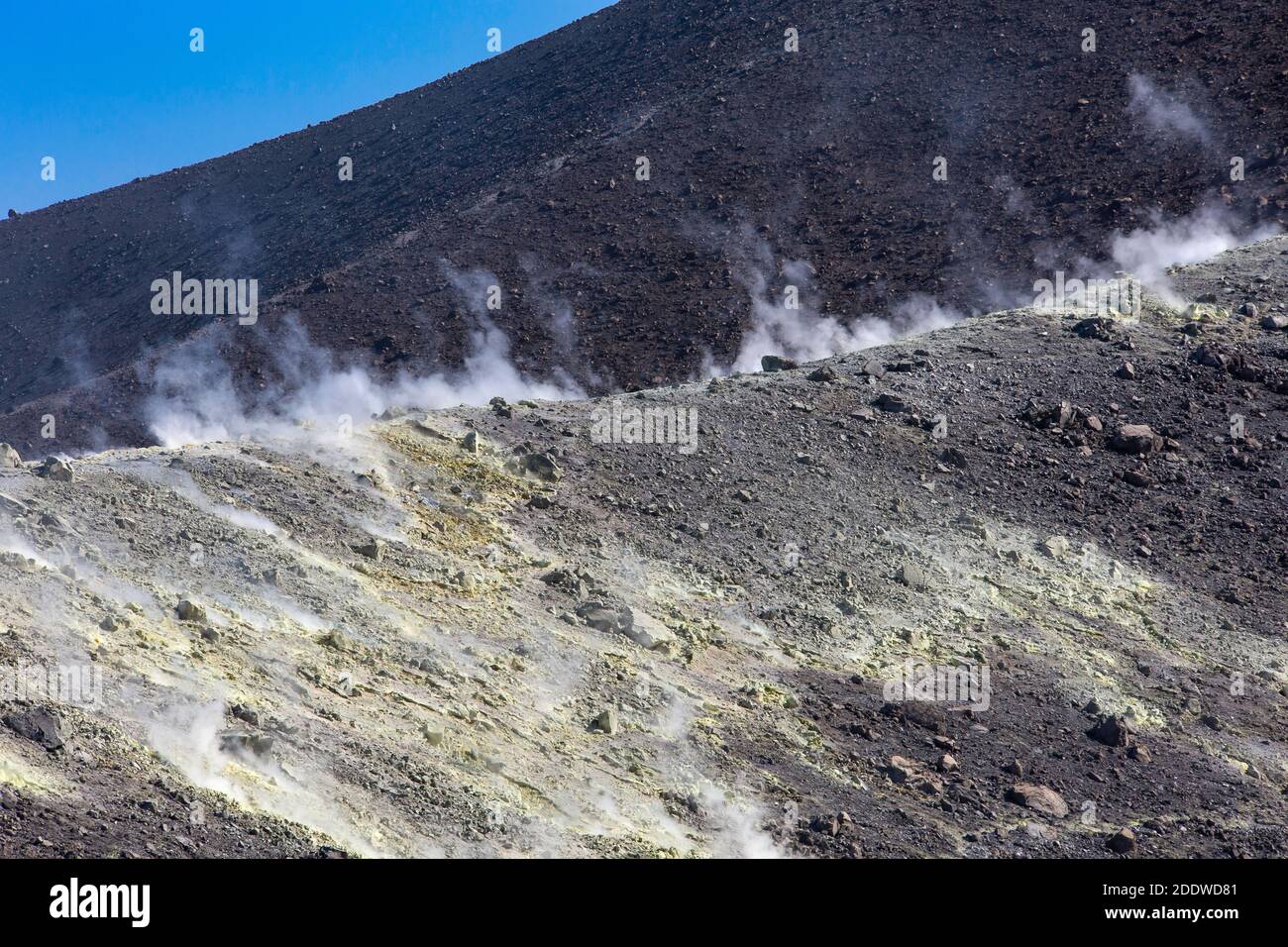 Sulfur haze and its crystals on the lava rocks. Volcano Island in the ...
