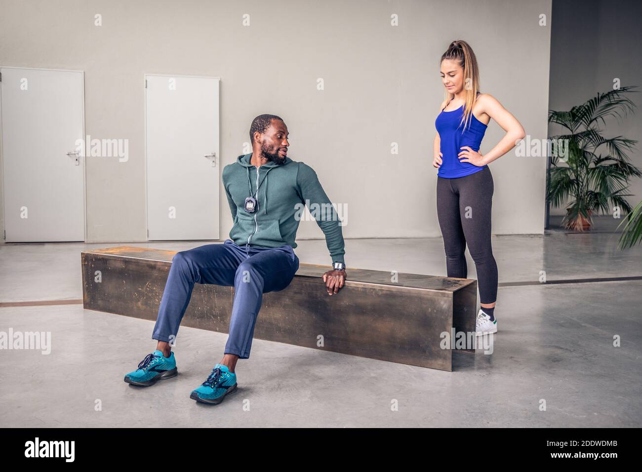The black coach show to the young girl how to perform the exercise in ...