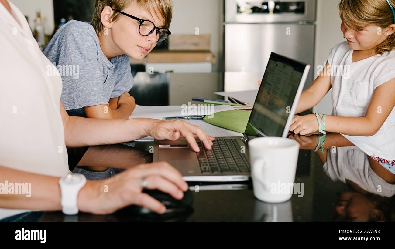 Stock photo of kids doing their homework at home with her mom Stock ...
