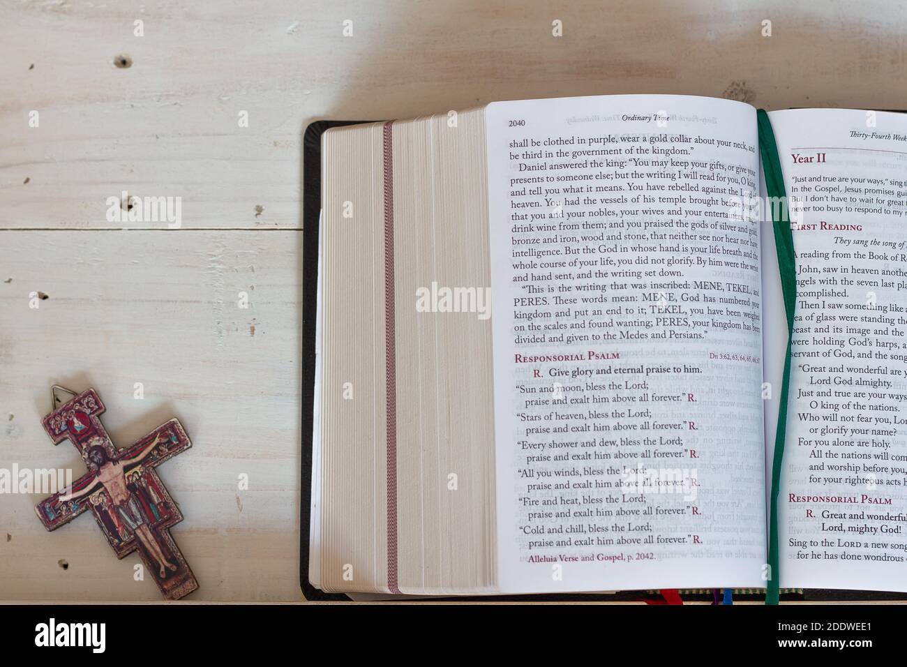 Catholic bible open with daily readings and crucifix on white wood ...