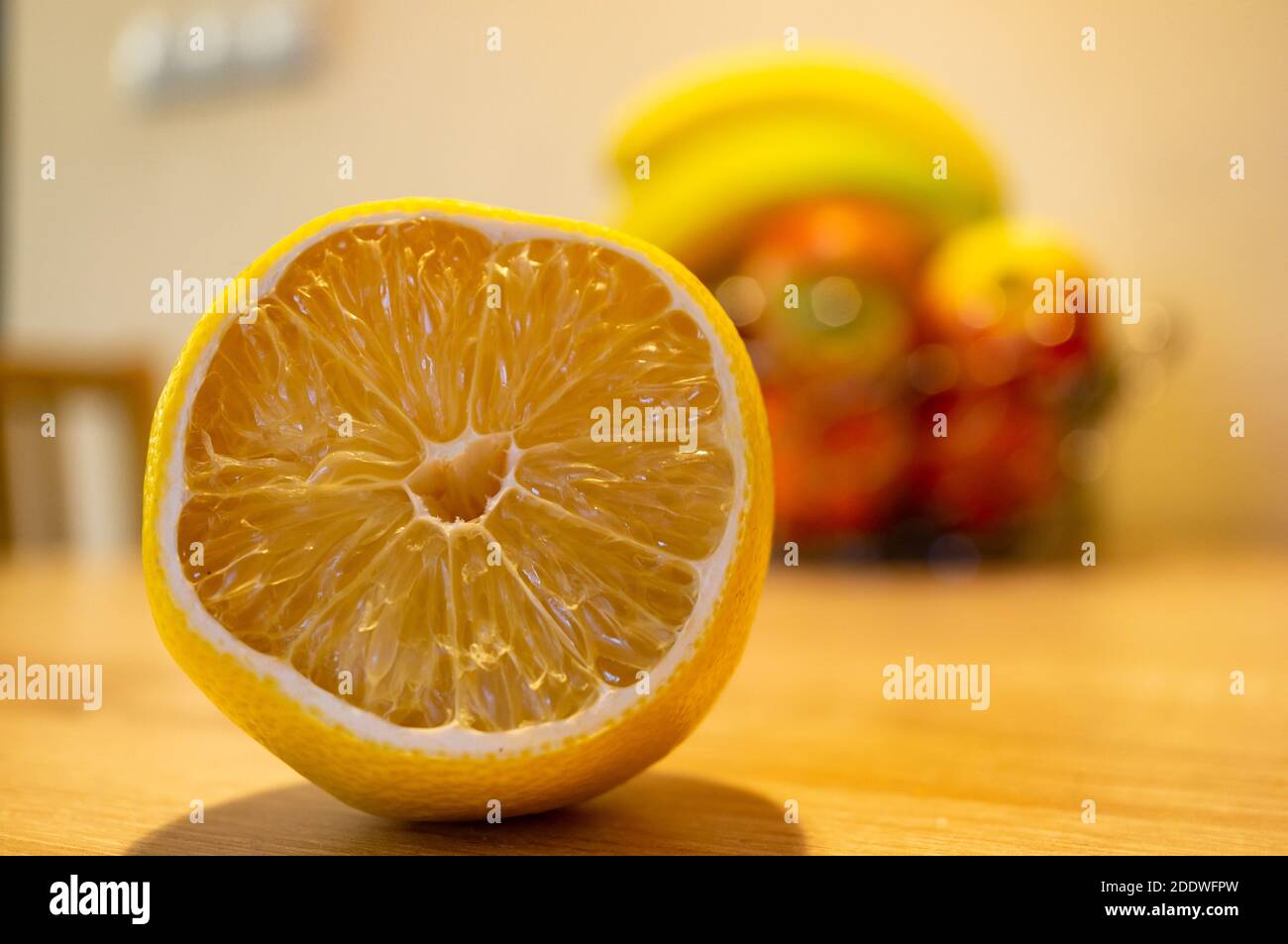 A close up shot of a cut lemon on a wooden table Stock Photo - Alamy