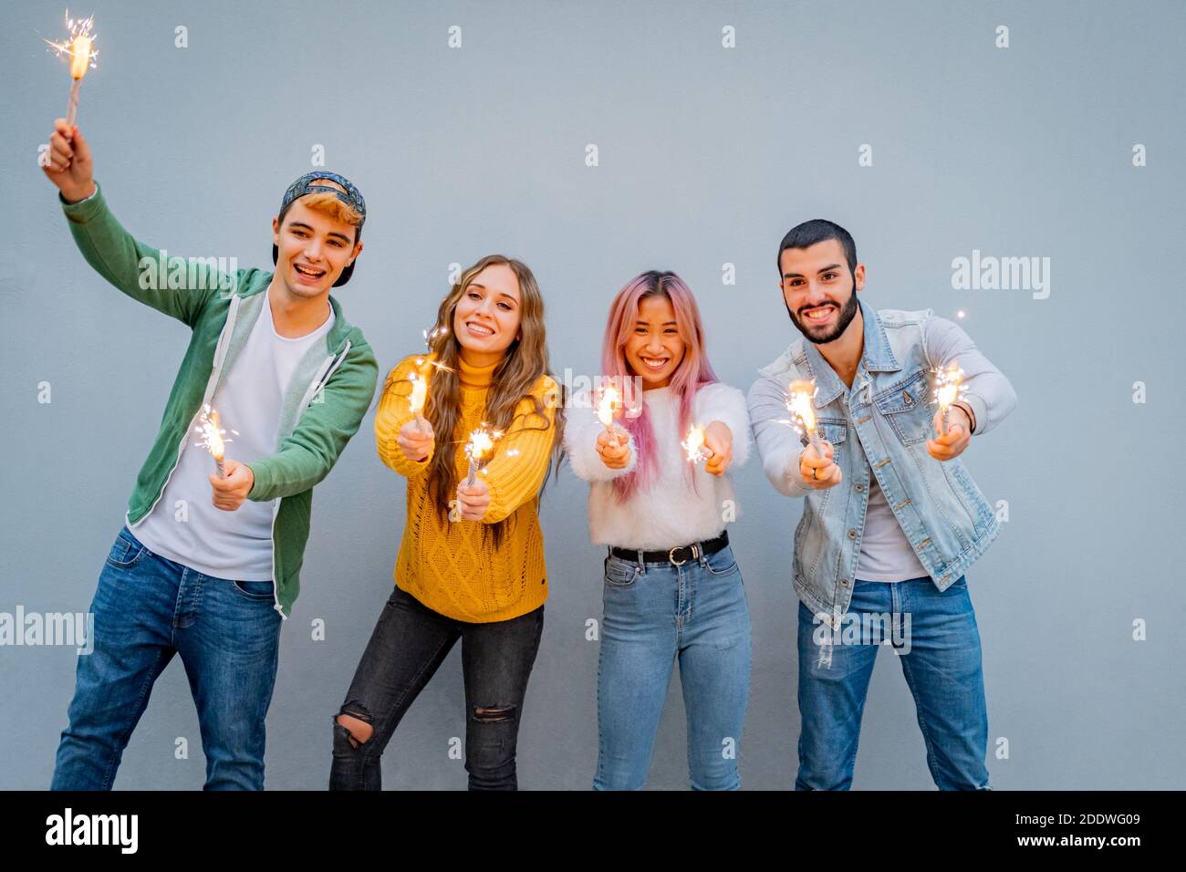 Group of multiethnic friends jocking with sparklers - People dancing ...