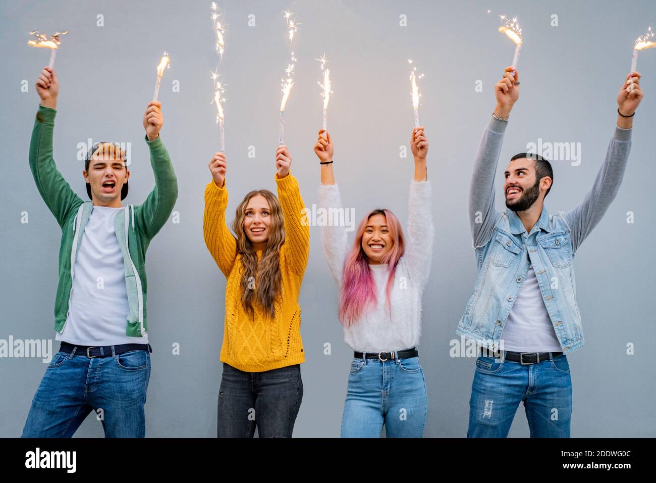Group of multiethnic friends jocking with sparklers - People dancing ...